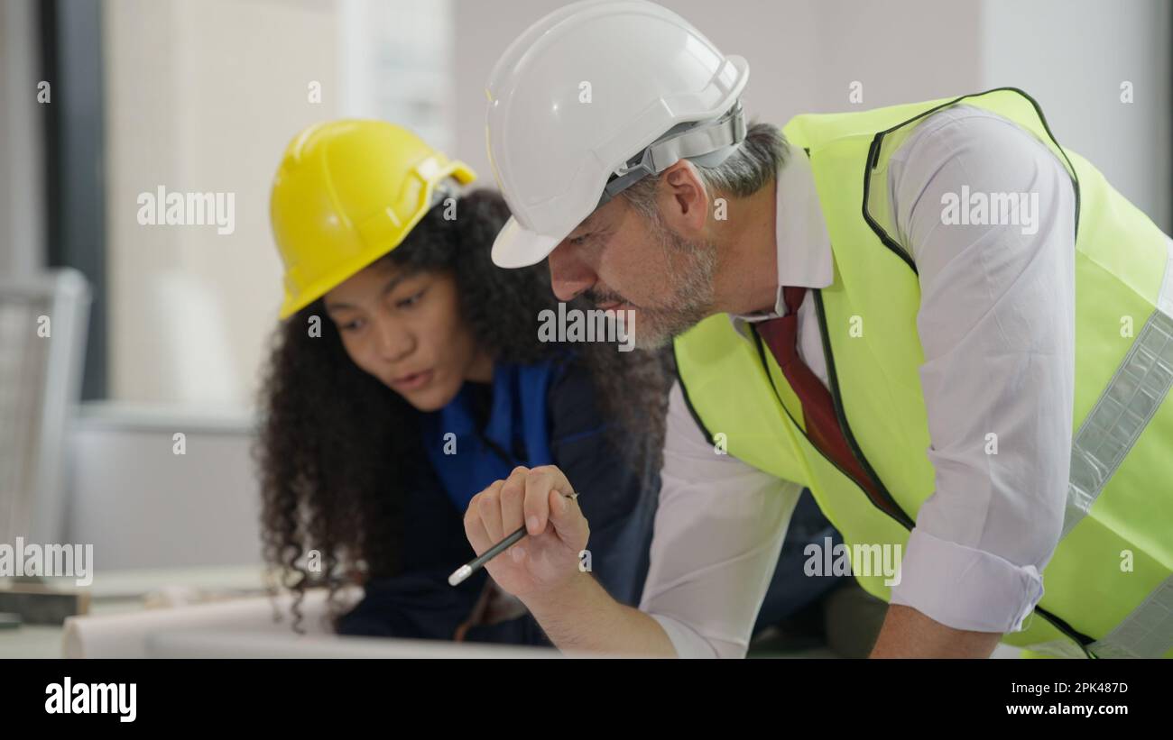 Professional construction engineers team using blueprint of project ...