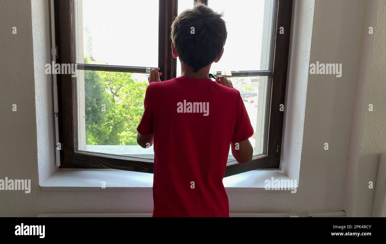 Child closing window. Young boy closes home window Stock Photo - Alamy