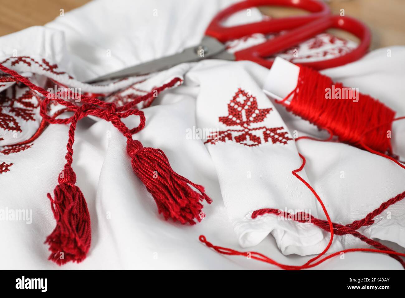 White shirt with beautiful embroidery design, thread and scissors ...