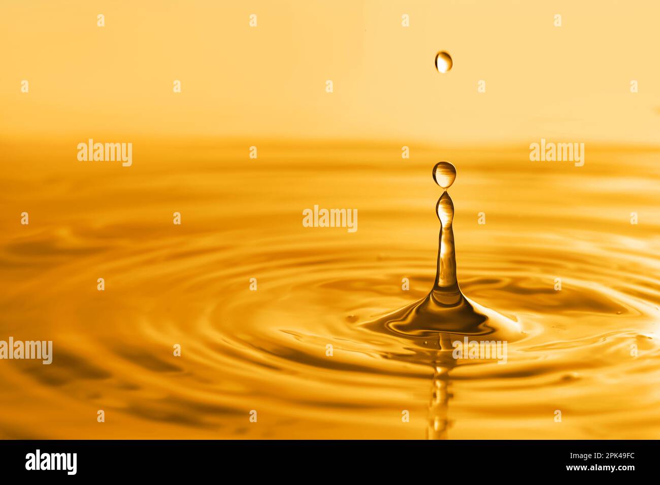 Splash of golden oily liquid with drops as background, closeup Stock ...