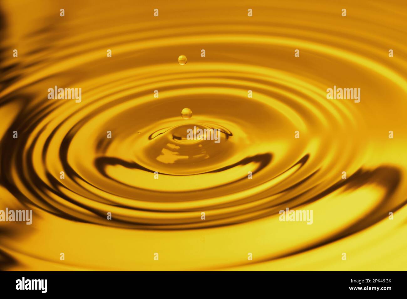 Splash of golden oily liquid with drops as background, closeup Stock ...