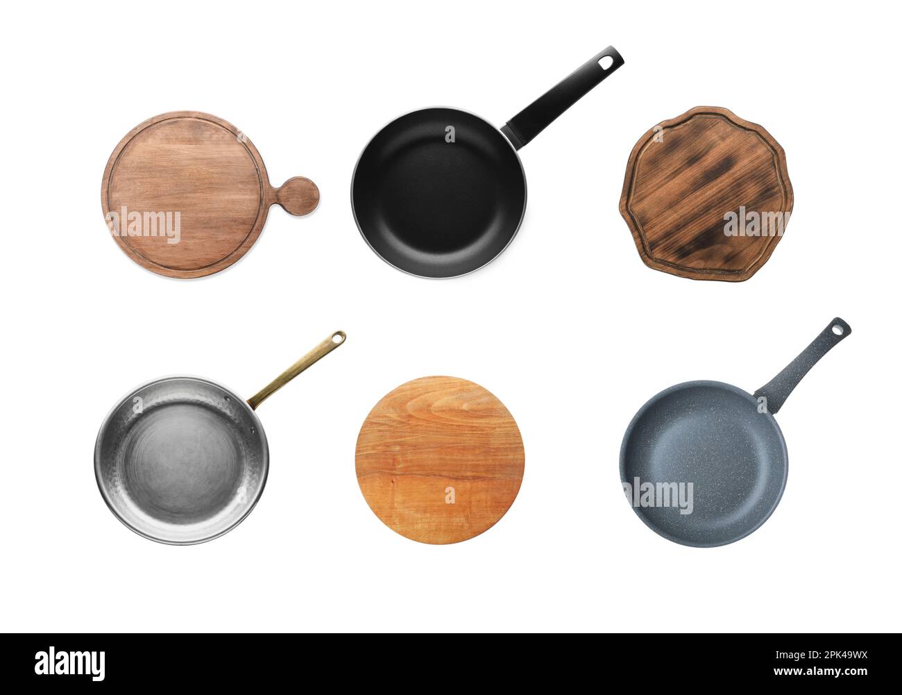 Set with pans and wooden cutting boards on white background, top view ...