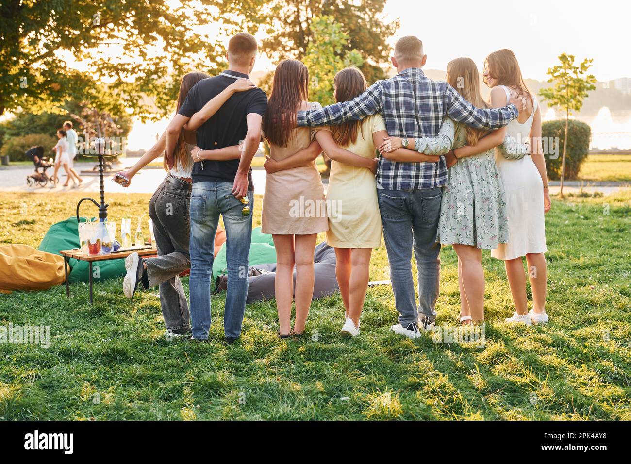 View from behind. Group of young people have a party in the park at ...