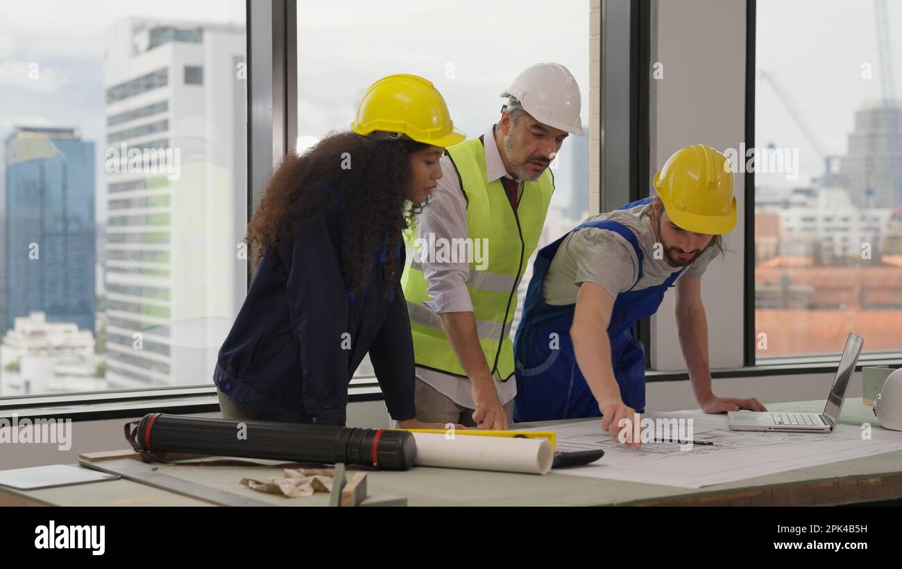 Professional construction engineers team using blueprint of project ...
