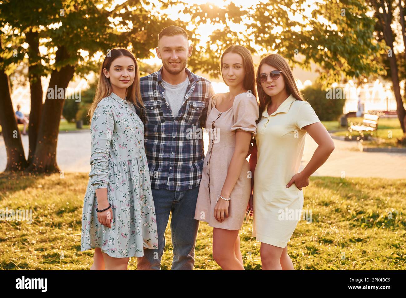 Man with three women standing in the park and embracing Stock Photo - Alamy