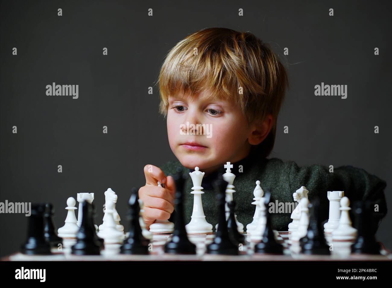 Concentrated child developing chess strategy, playing board game with ...