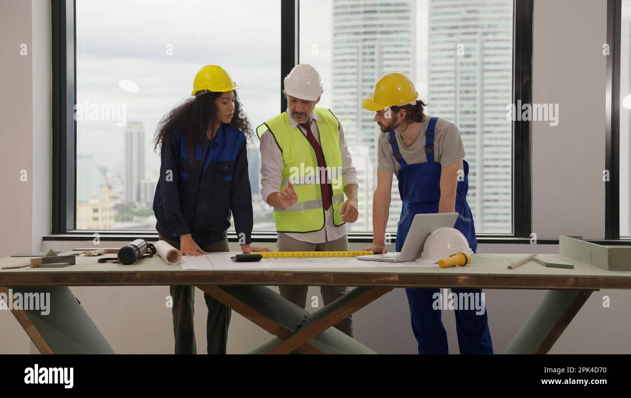 Professional construction engineers team using blueprint of project plan Stock Photo - Alamy