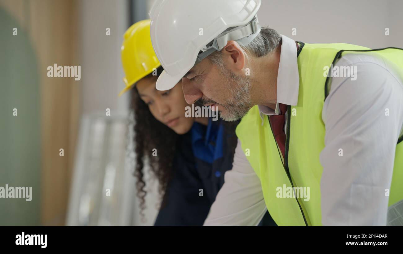 Professional construction engineers team using blueprint of project ...