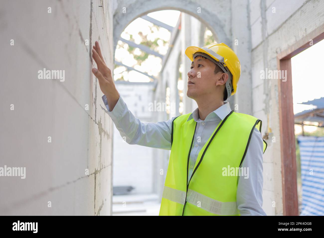 Asian engineer in uniform at construction site while checking and ...