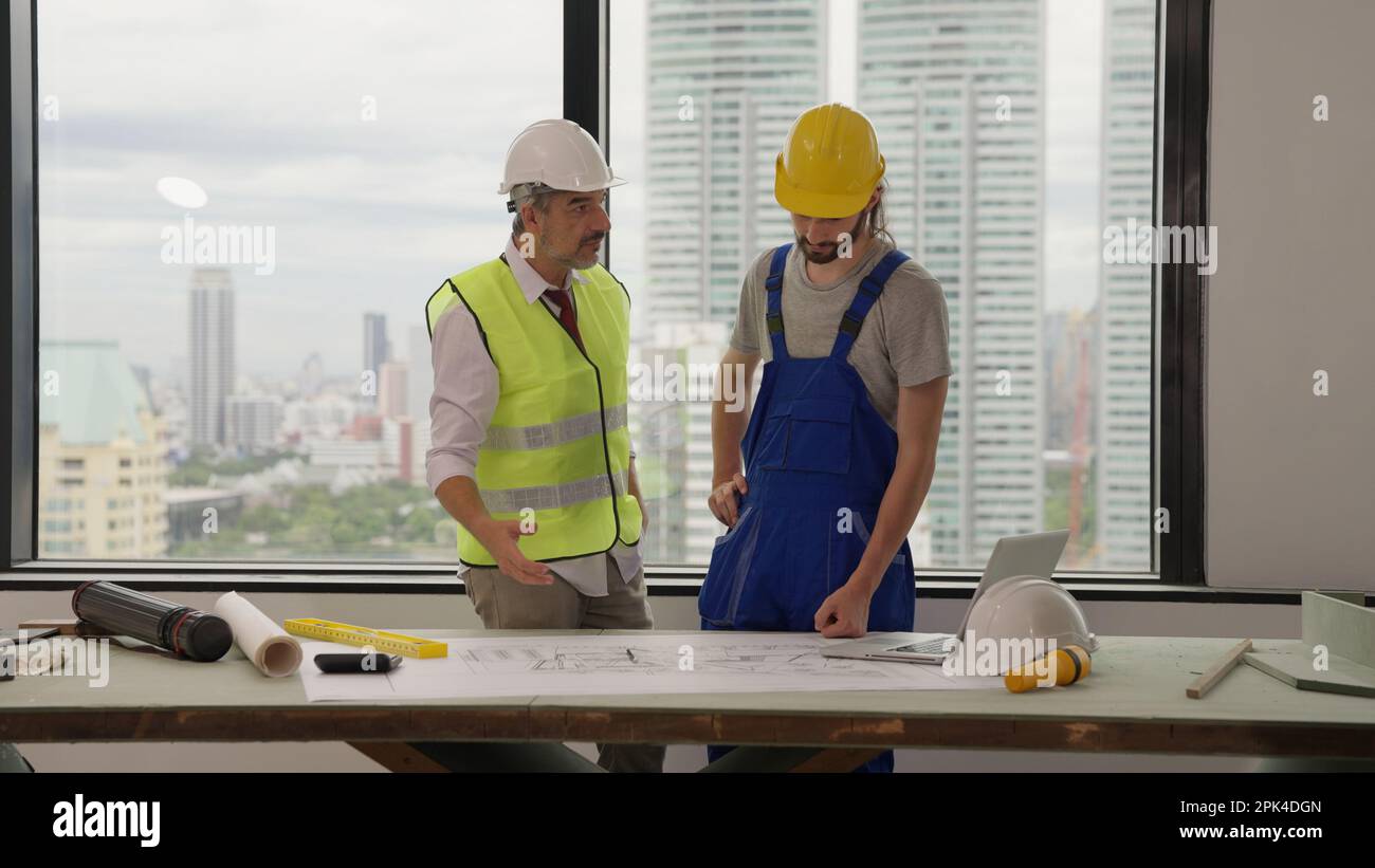 Professional construction engineers team using blueprint of project ...