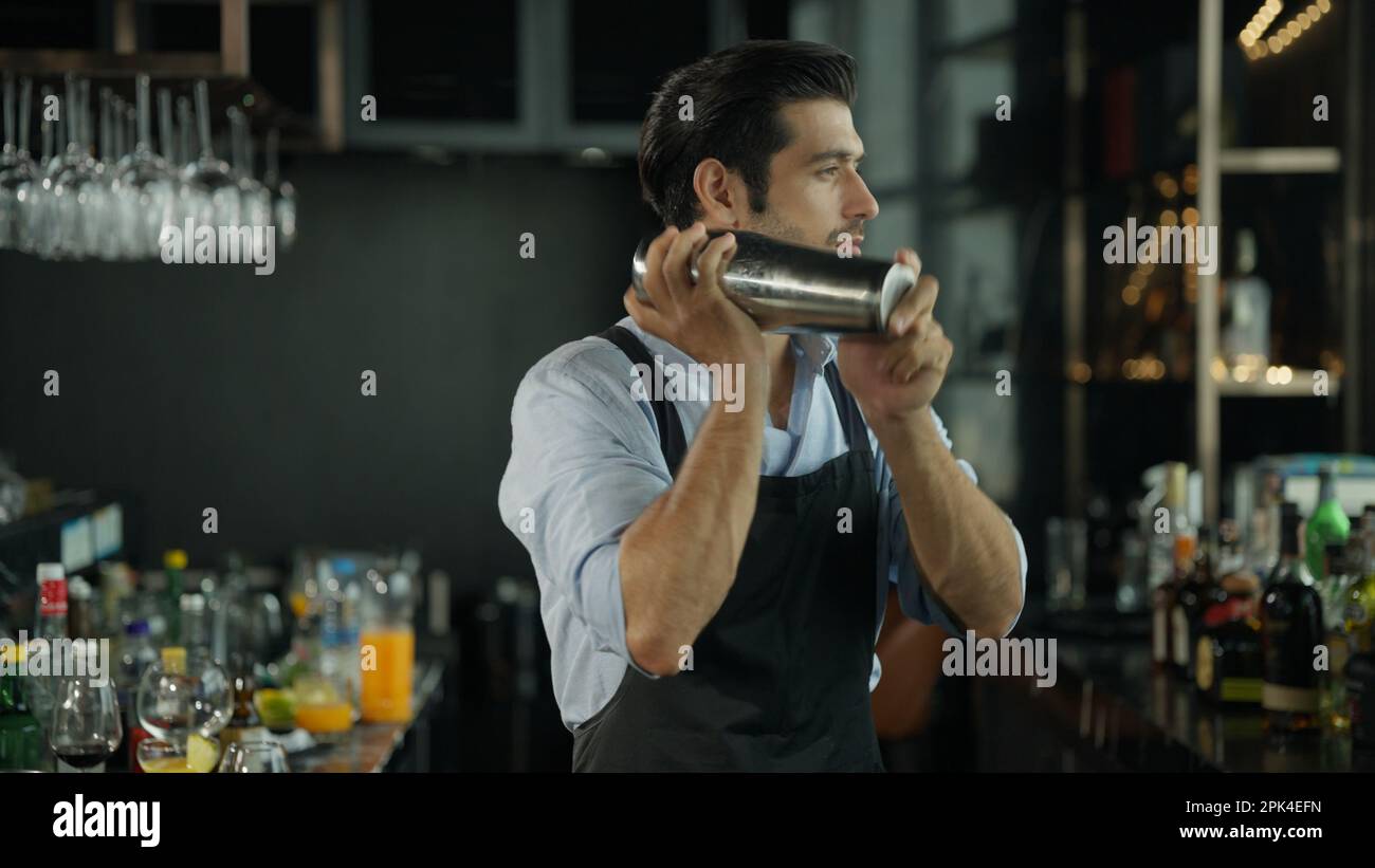 Smart bartender in black apron preparing cocktail Stock Photo - Alamy