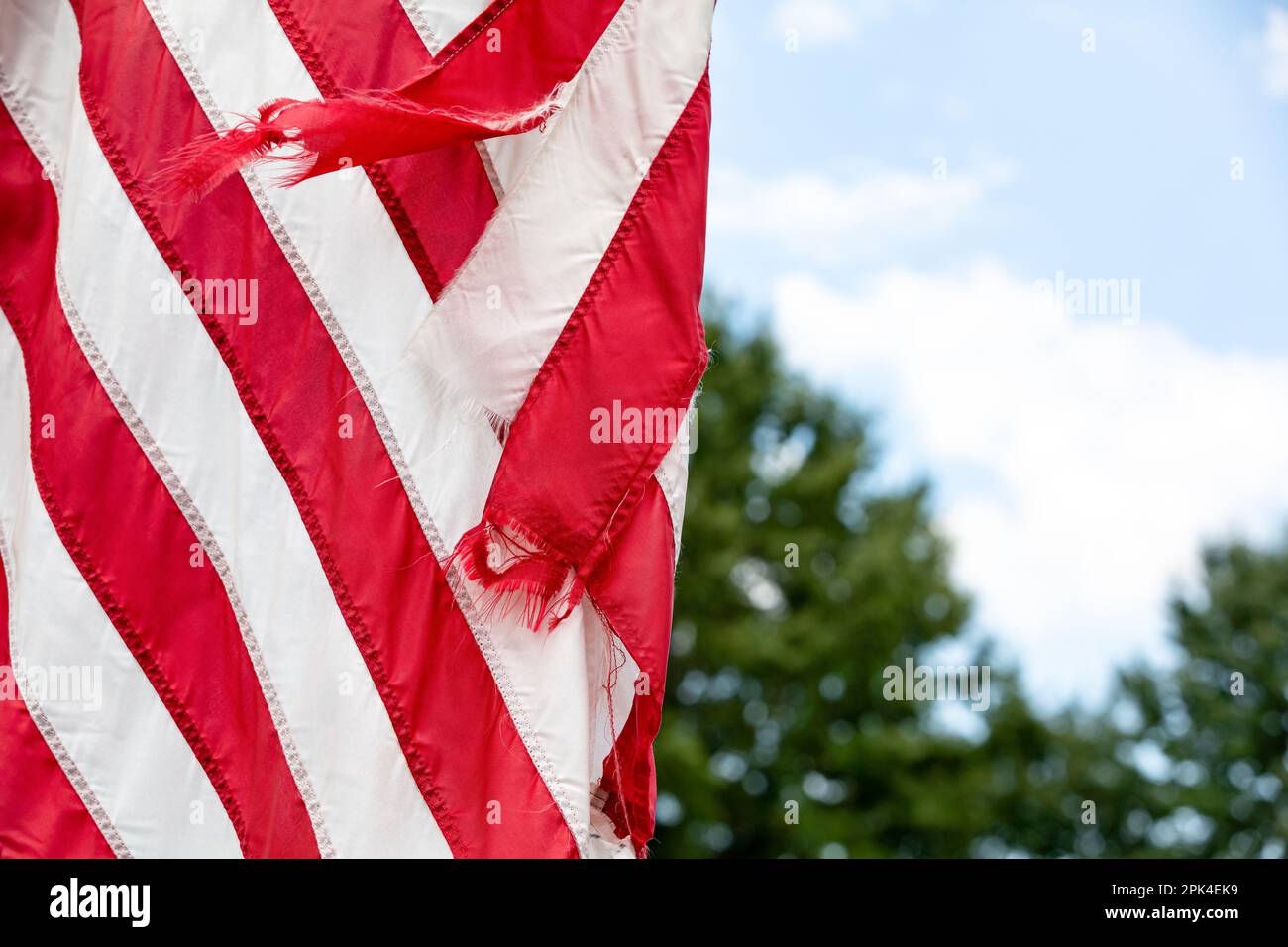 Old, tattered and torn American Flag flying outdoors. Patriotic and ...