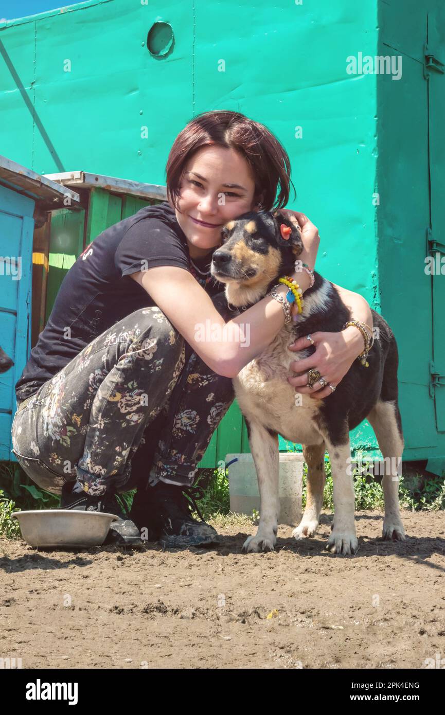 Dog at the shelter. Animal shelter volunteer feeding the dogs. Lonely ...