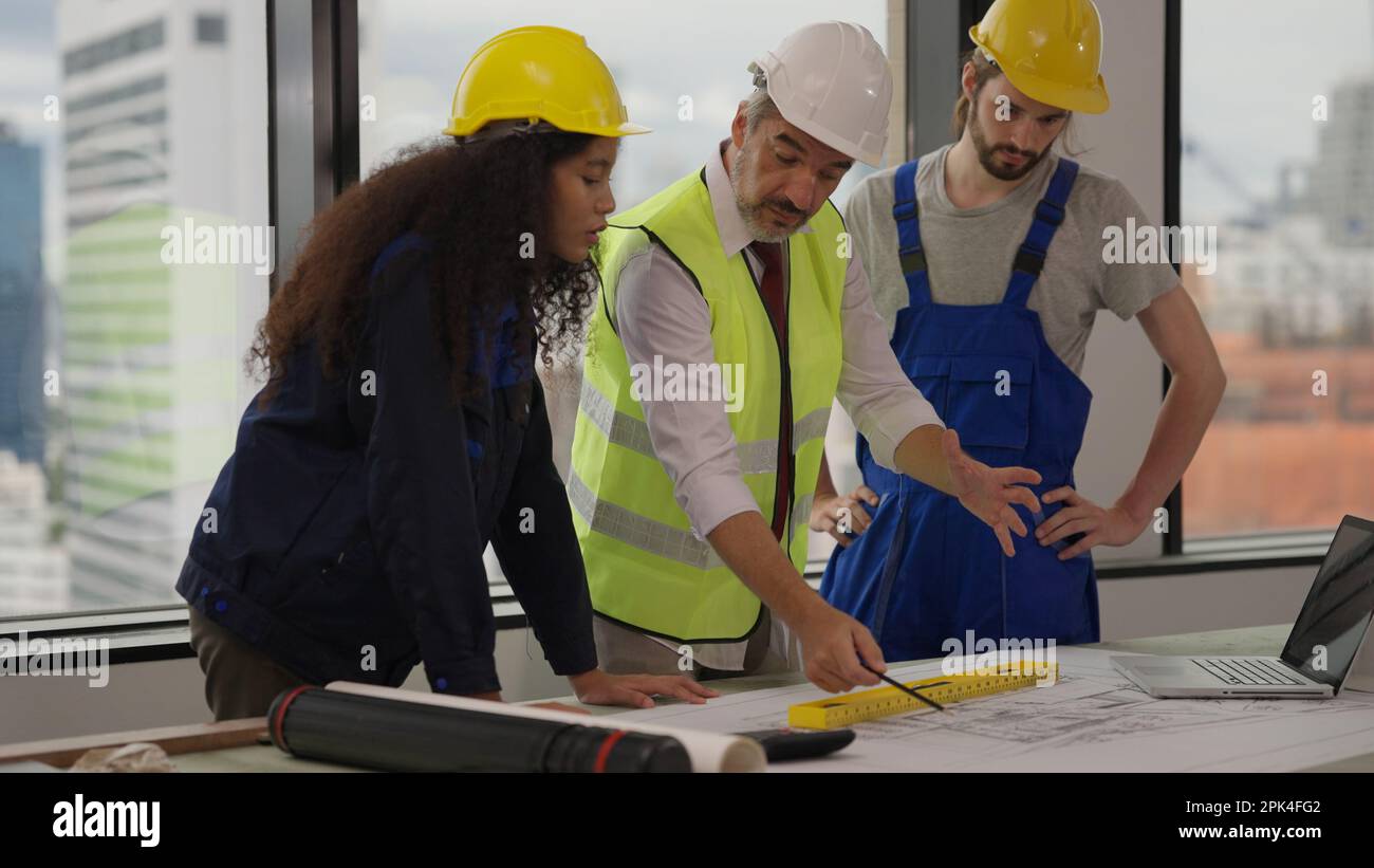 Professional construction engineers team using blueprint of project ...