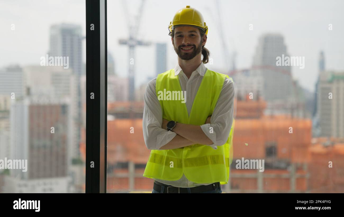 Portrait of confident engineer with safety helmet and vest on building ...