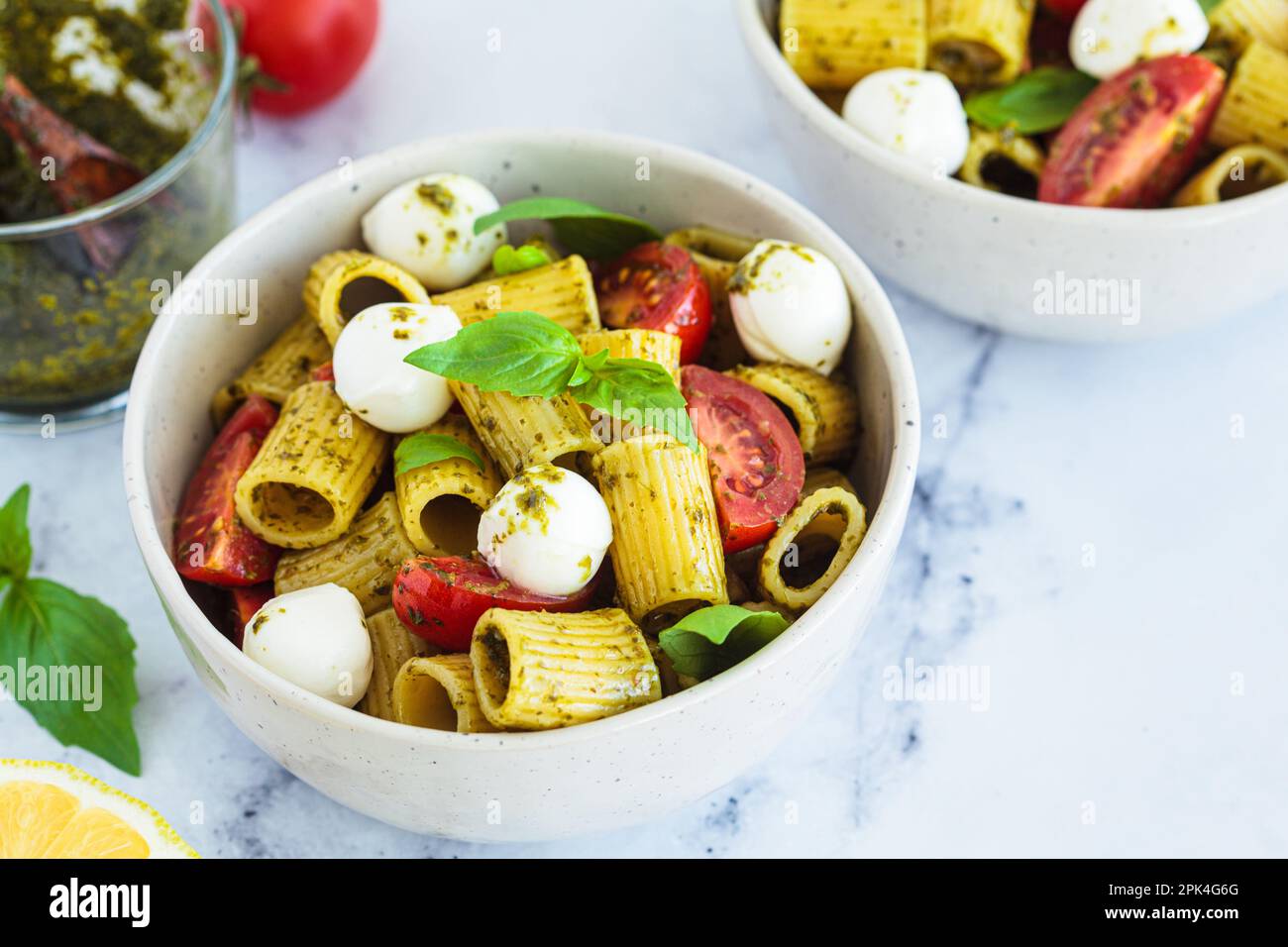 Vegetarian rigatoni pasta with pesto, tomatoes and mozzarella in white ...