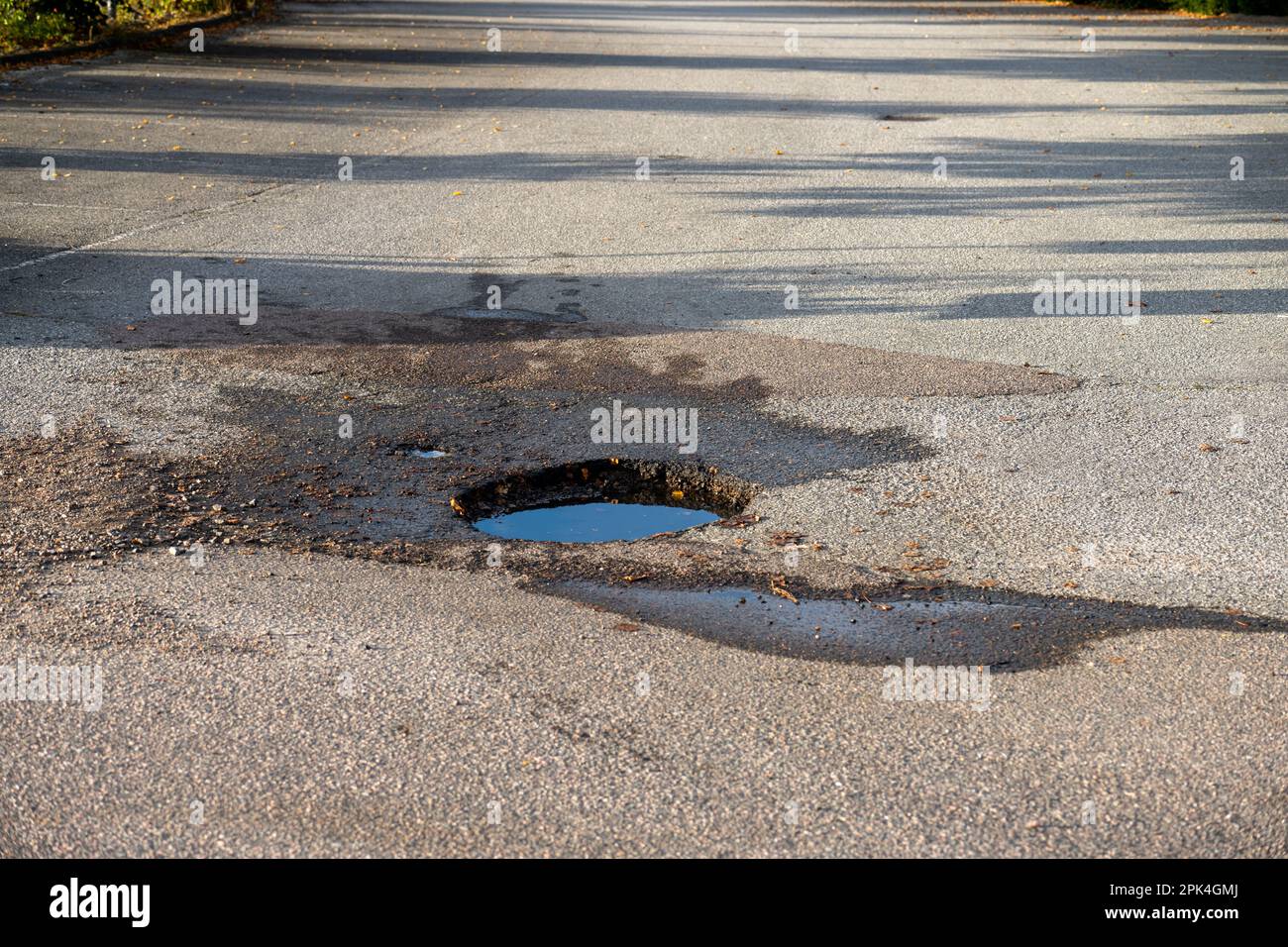 A dep pothole in asphalt parking lot filled with water Stock Photo - Alamy