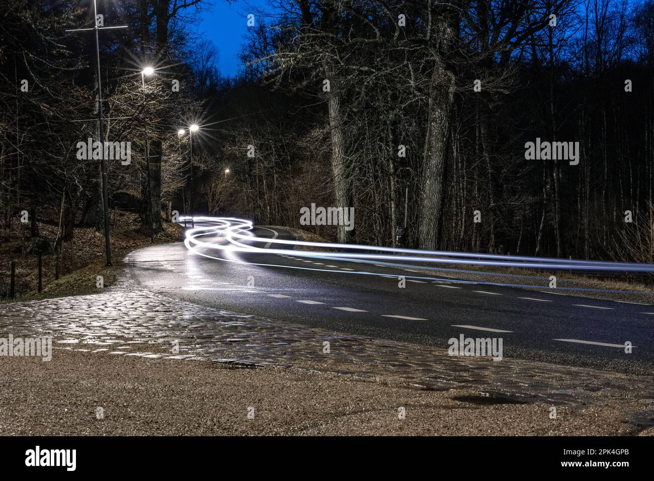 Headlight trails of a car driving down a curvy road at night Stock ...