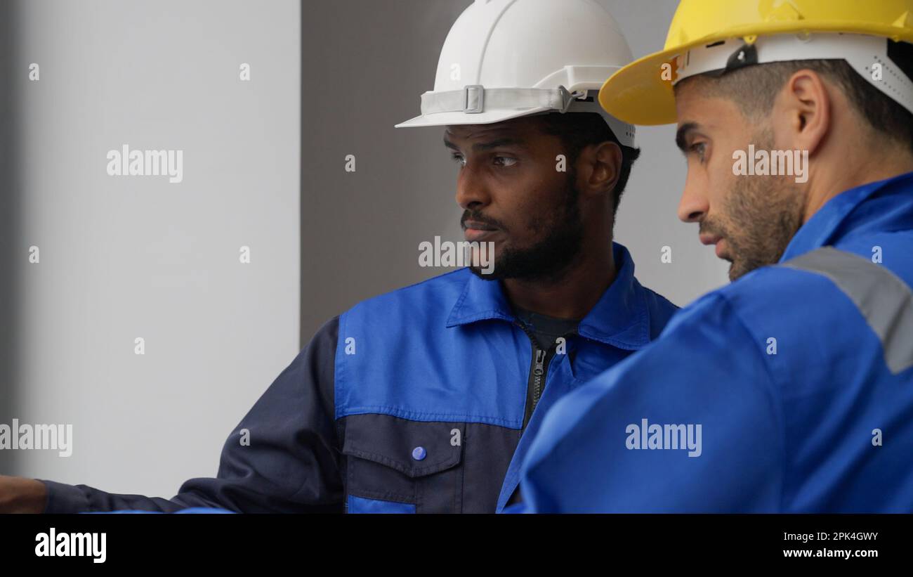 Professional electricians workers with safety helmet talking and ...