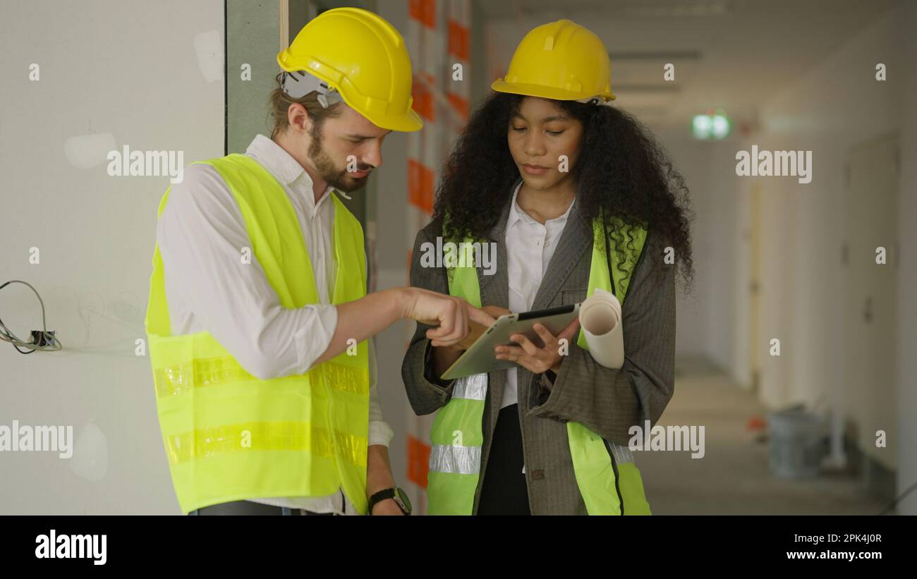 Engineers using tablet talking and brainstorming together on ...