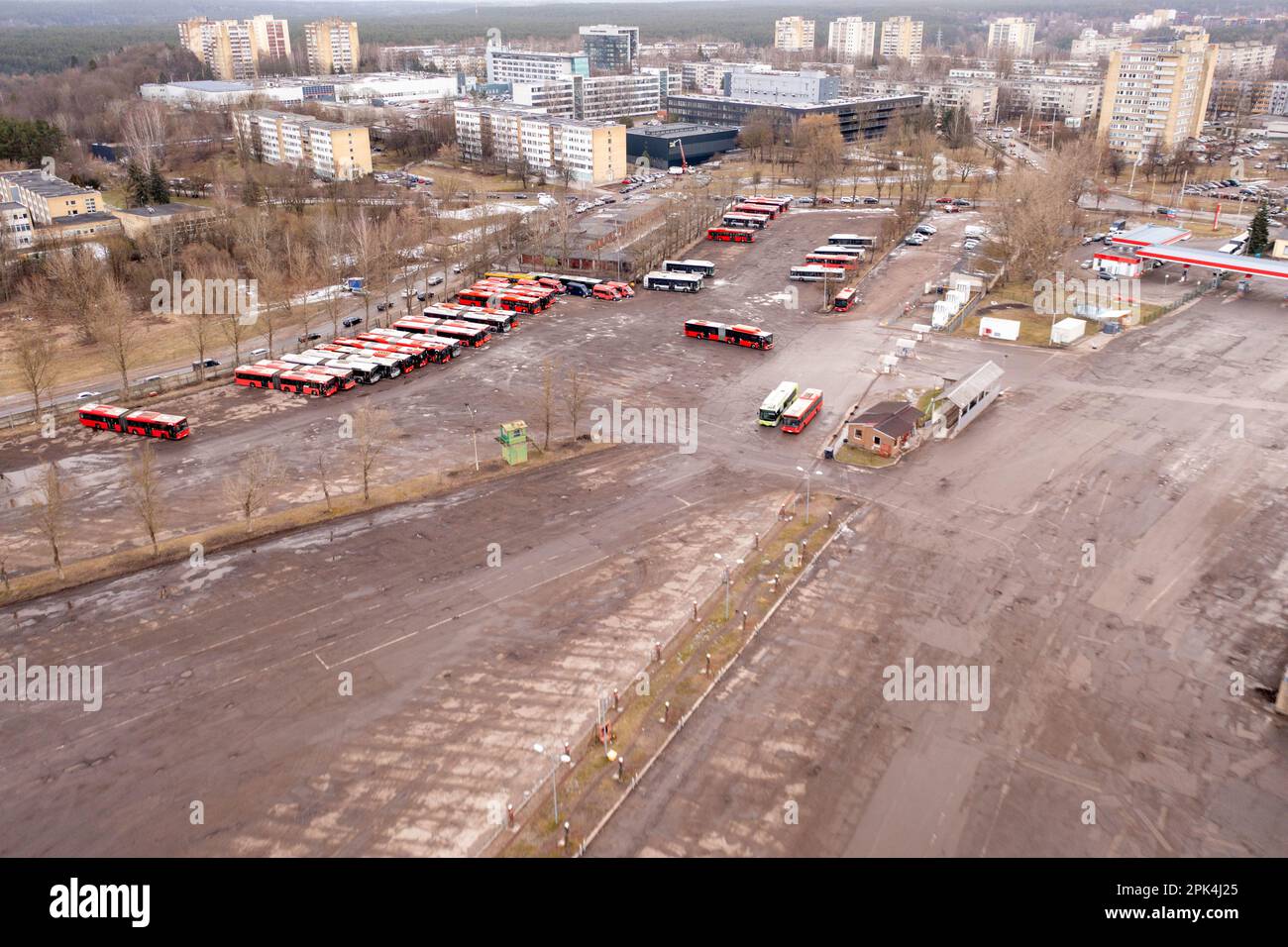 Drone photography of city bus park, lots of parked buses and cityscape ...