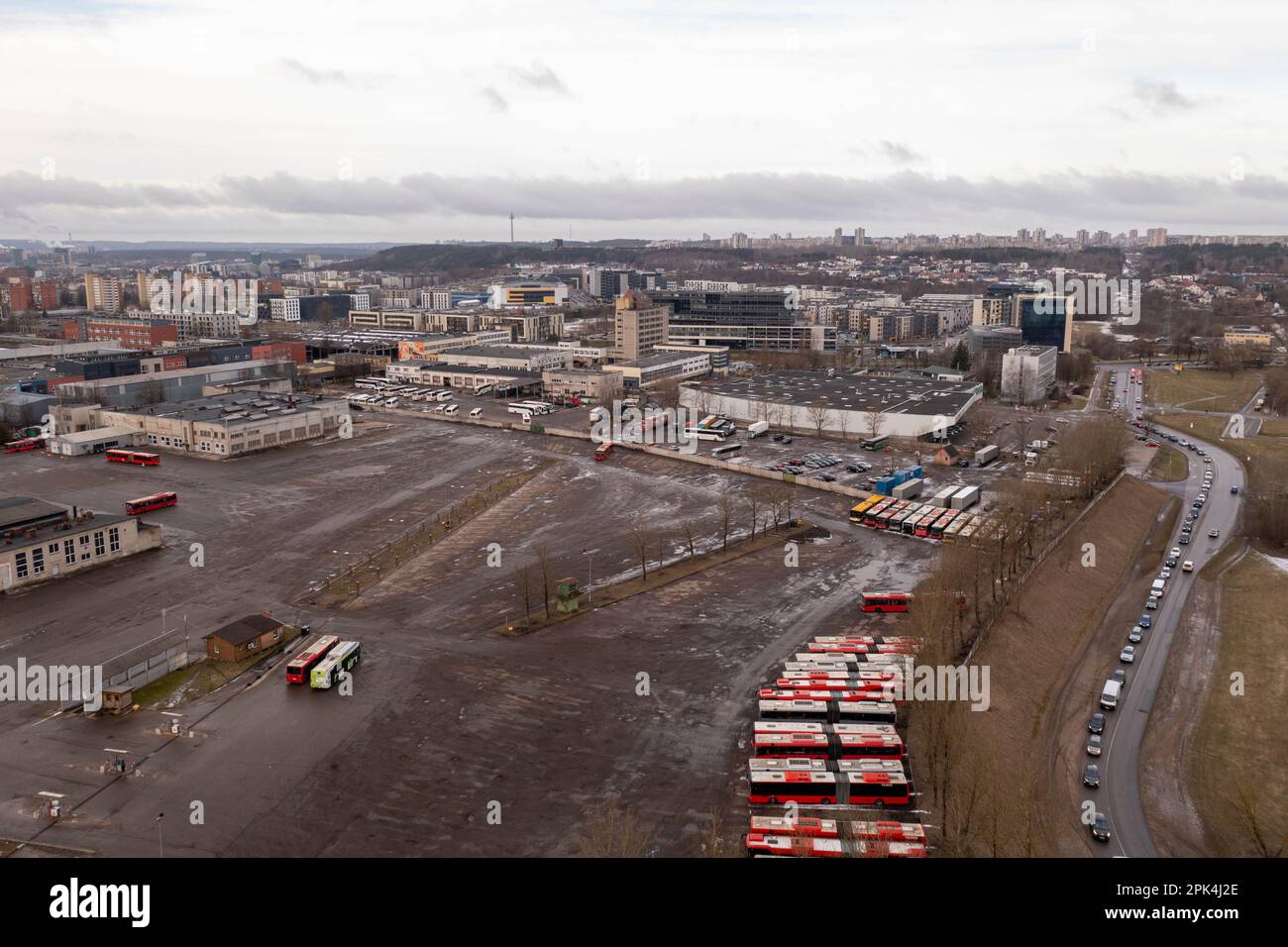 Drone photography of city bus park, lots of parked buses and cityscape ...