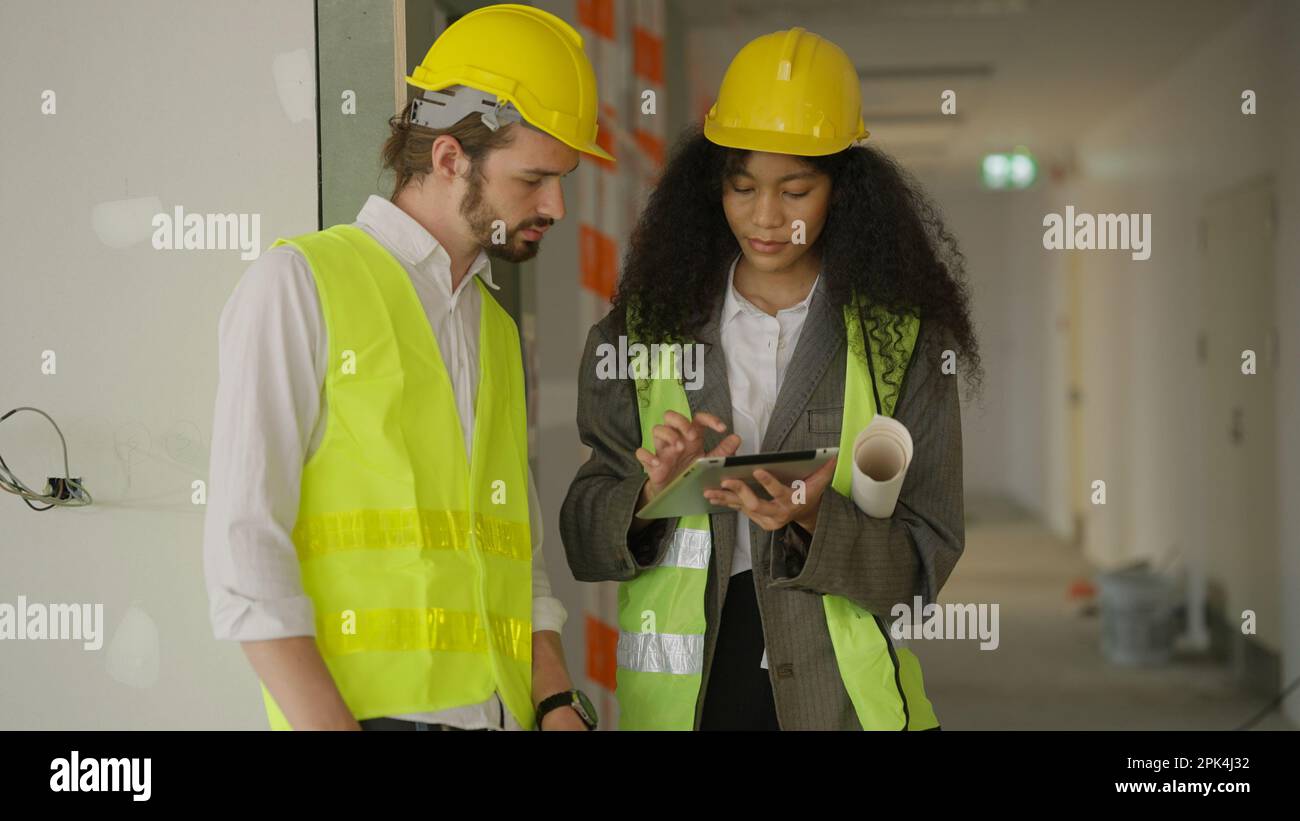 Engineers using tablet talking and brainstorming together on ...