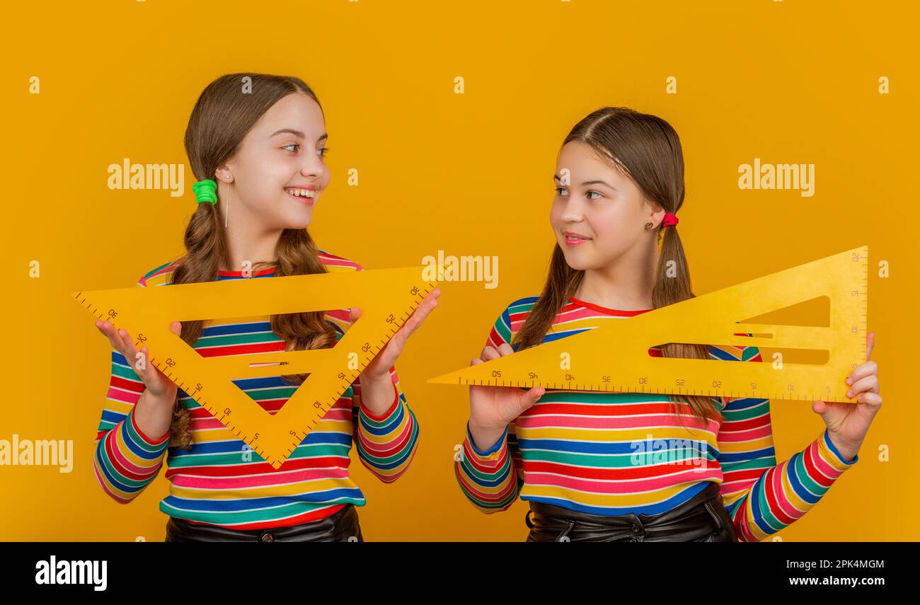 cheerful school kids hold math tool of triangle Stock Photo - Alamy