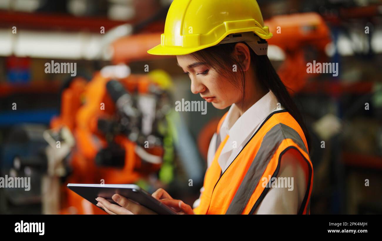 Confident female industrial engineer with safety uniform protection ...