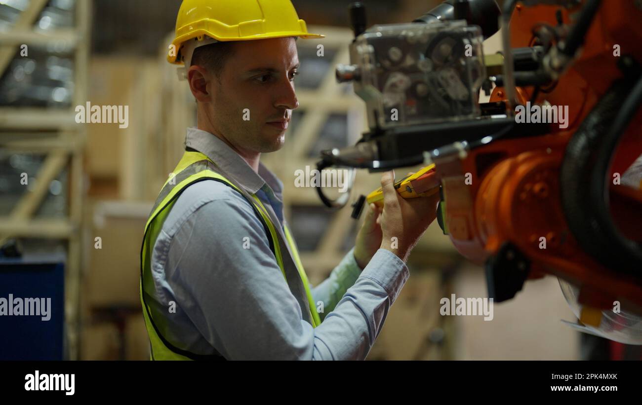Maintenance engineer with robotic arms at industrial factory Stock ...