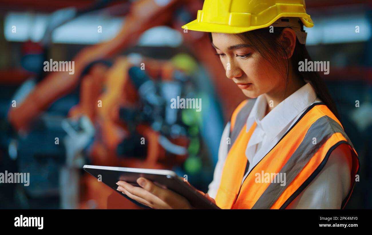 Confident female industrial engineer with safety uniform protection ...
