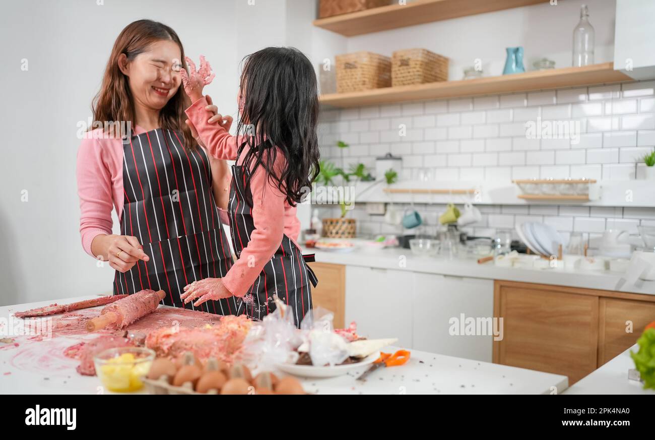 Child making cake with family, Family having fun together in kitchen ...