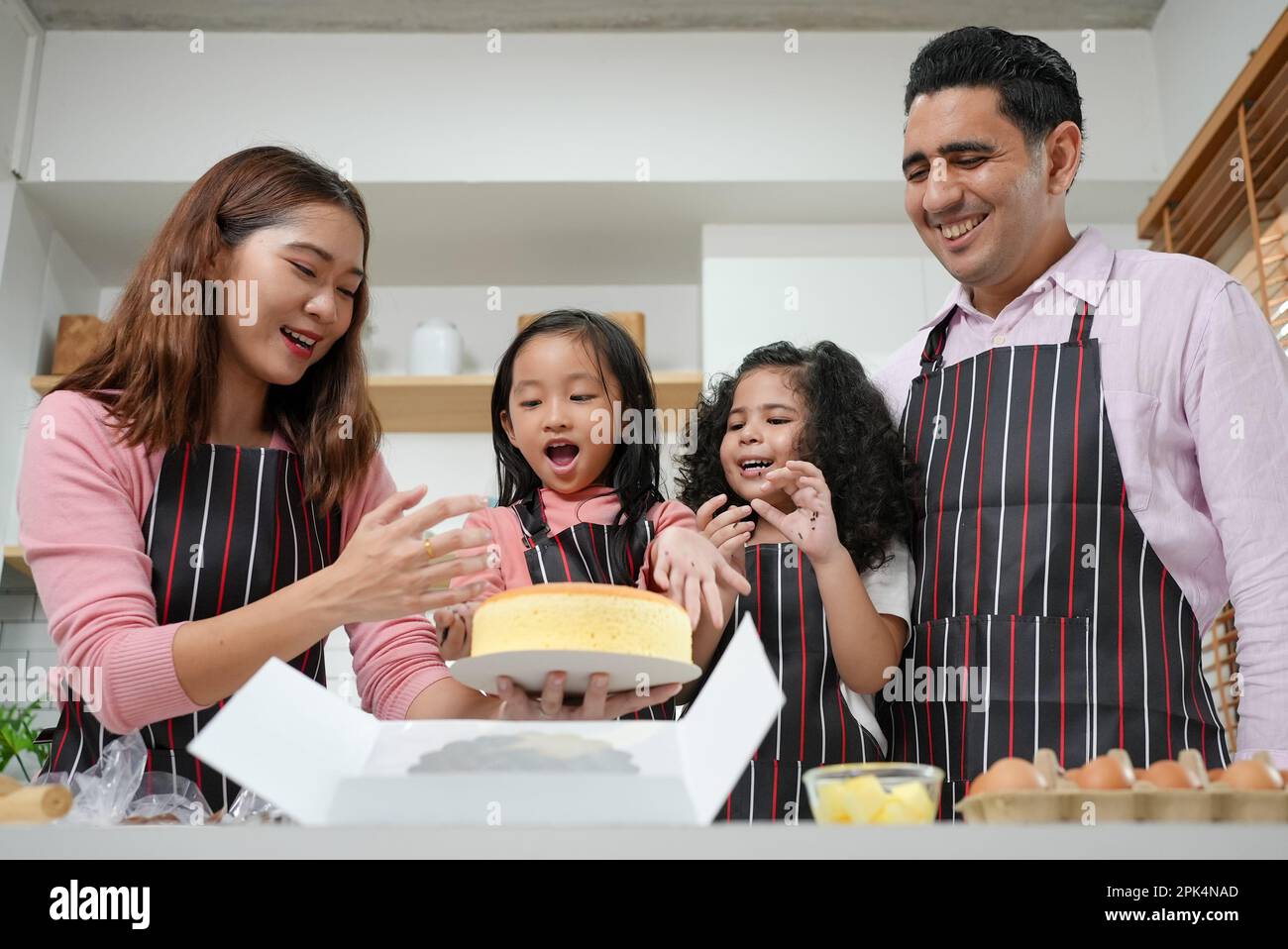 Child making cake with family, Family having fun together in kitchen ...