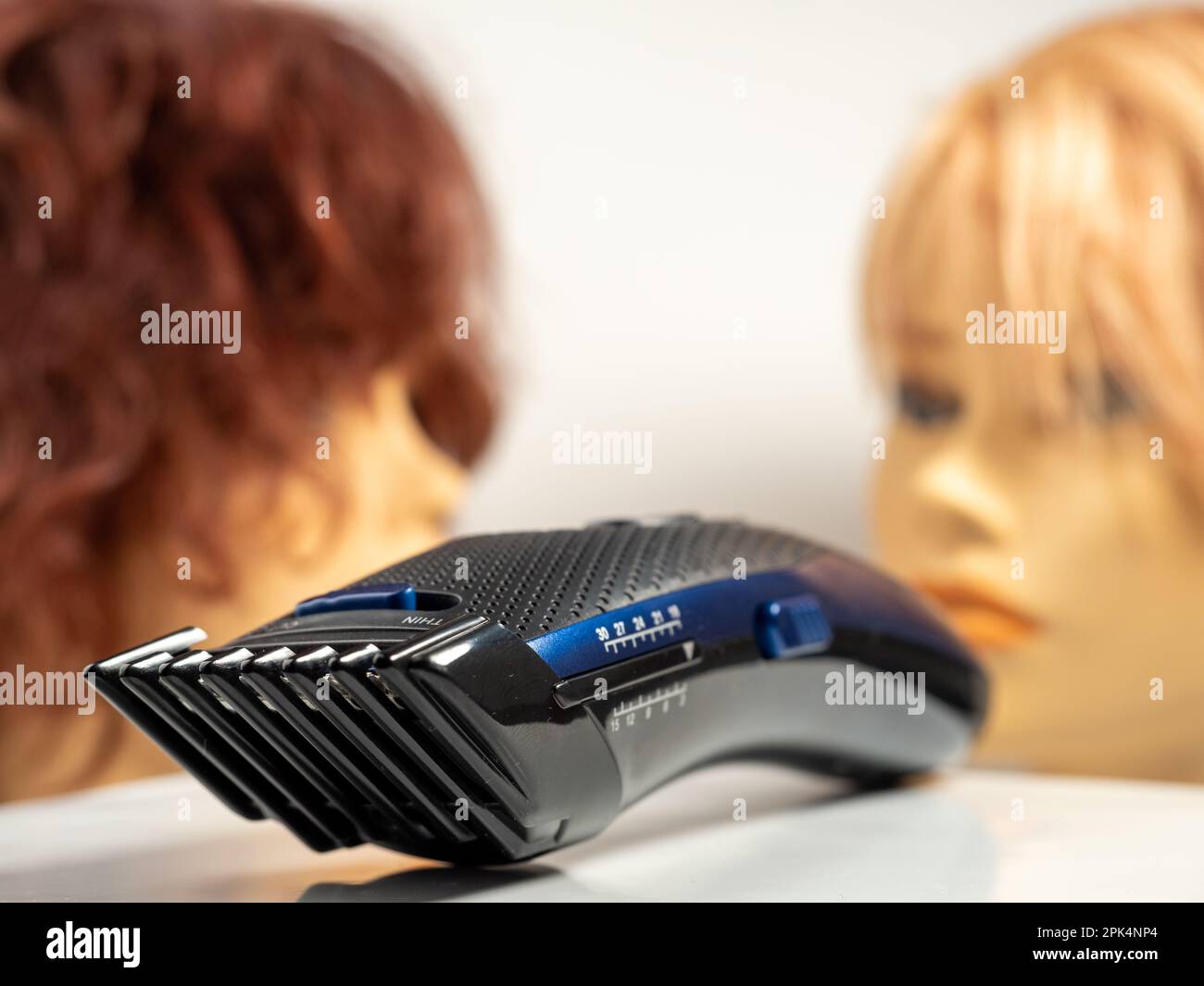 Hair clipper on the background of training mannequins. . Modern hair ...