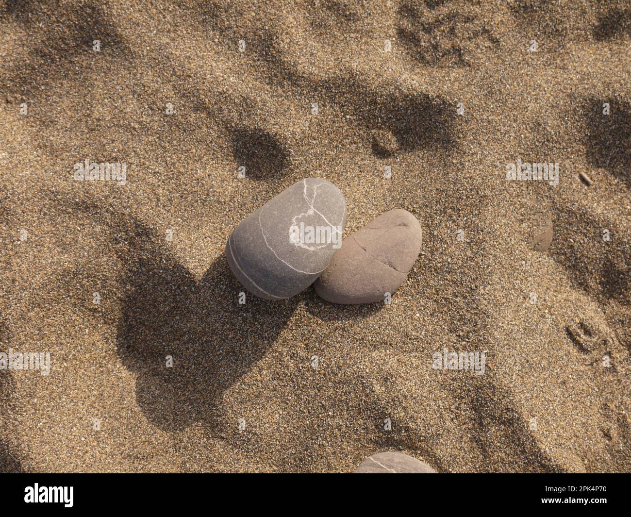 Two pebbles on a sandy beach, Widemouth Bay, Cornwall, UK Stock Photo ...