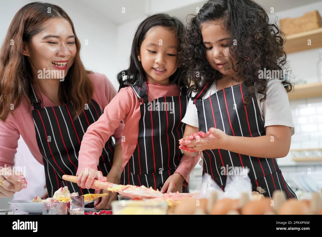 Child making cake with family, Family having fun together in kitchen ...