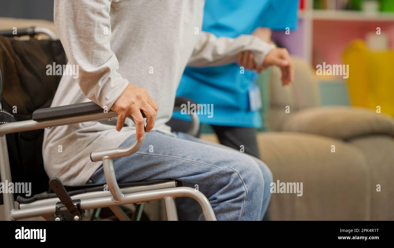 Elderly patient on wheelchair trying to stand and exercising with caregiver Stock Photo - Alamy
