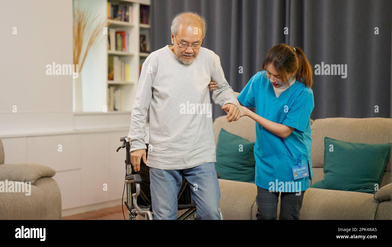 Elderly patient on wheelchair trying to stand and exercising with caregiver Stock Photo - Alamy