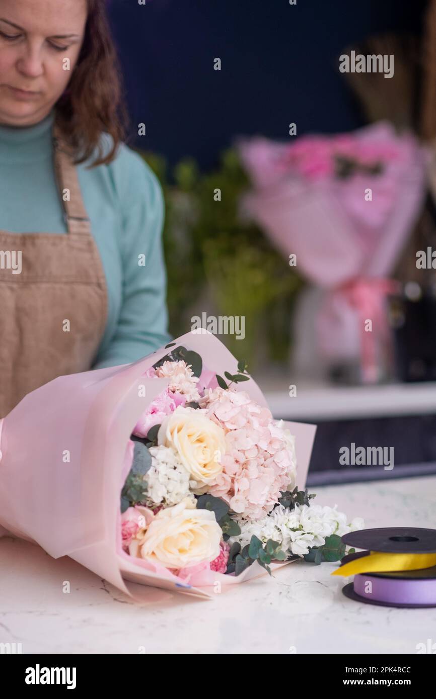 modern floral shop, skilled flower shop assistant prepares and creates ...