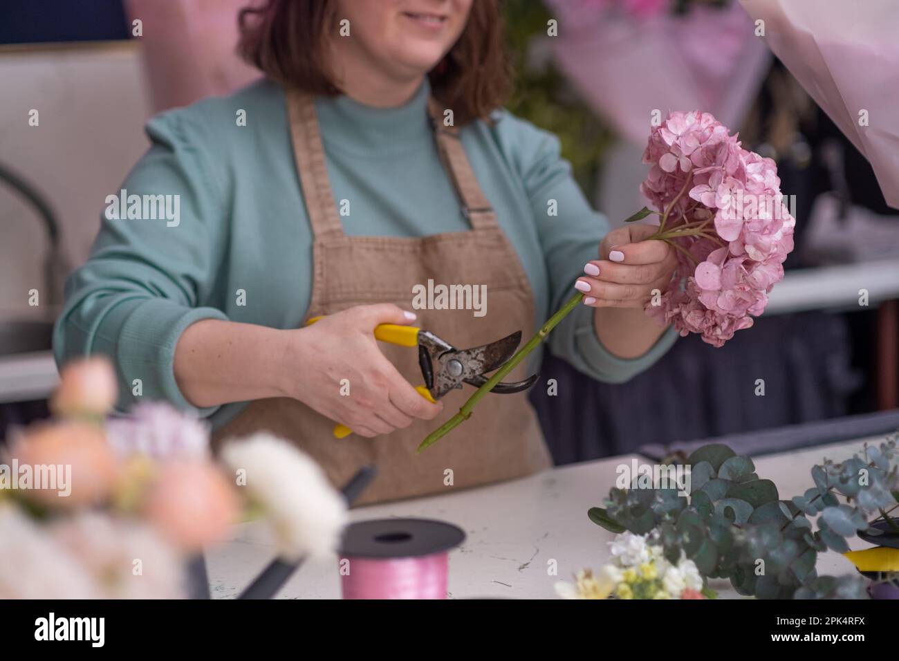 In the flower store woman professional florist, choosing flowers and ...