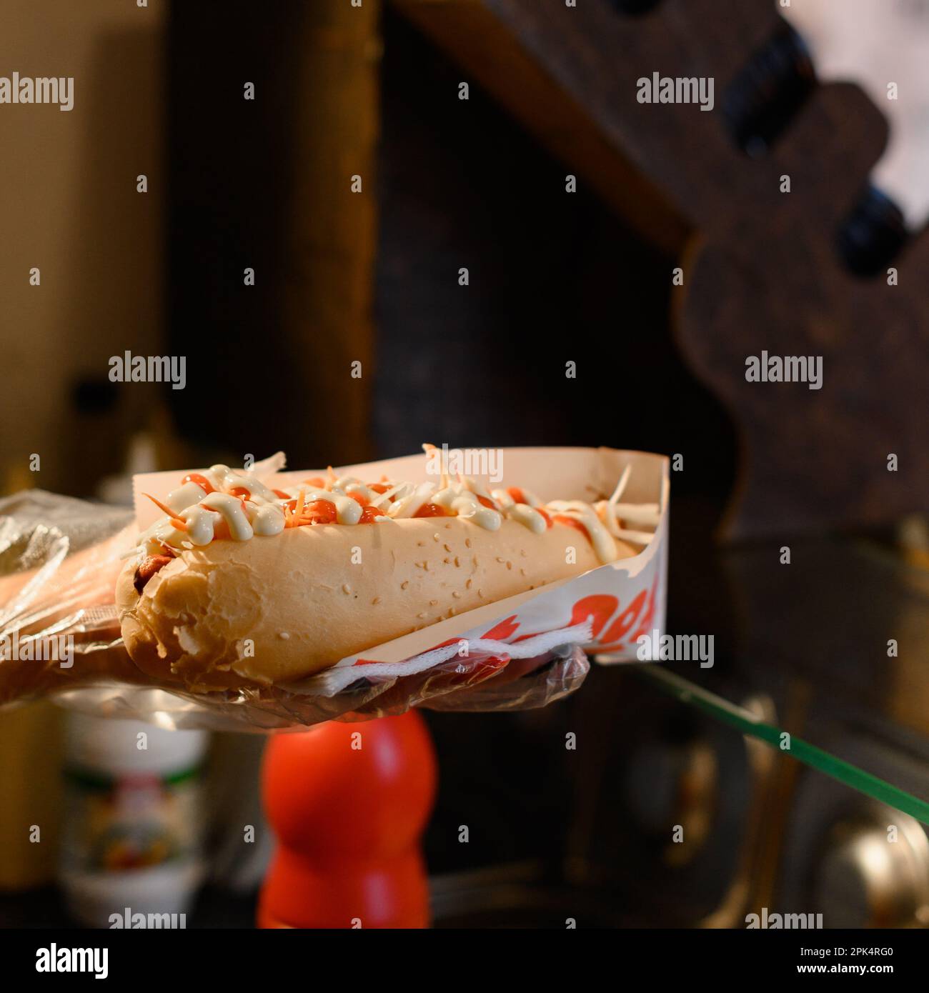 The process of making a hot dog, a worker fulfills a customer's order ...