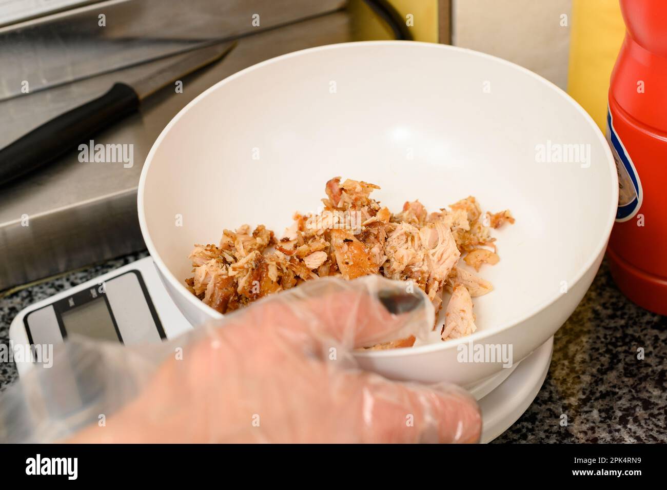 Weighing in a bowl of chopped and already cooked fried chicken, fast ...