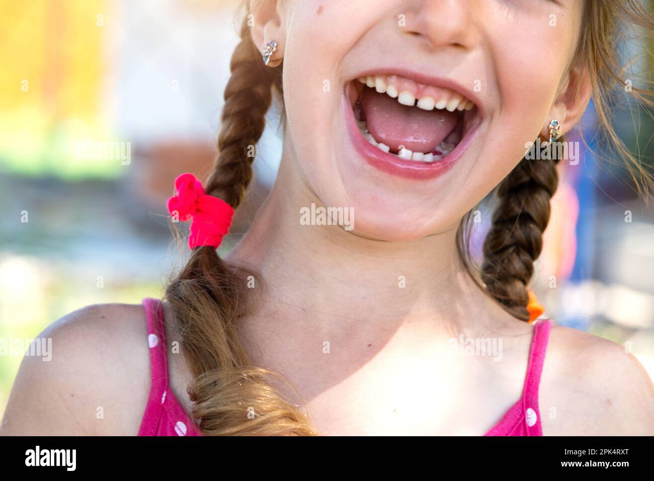 Toothless happy smile of a girl with a fallen lower milk tooth close-up ...