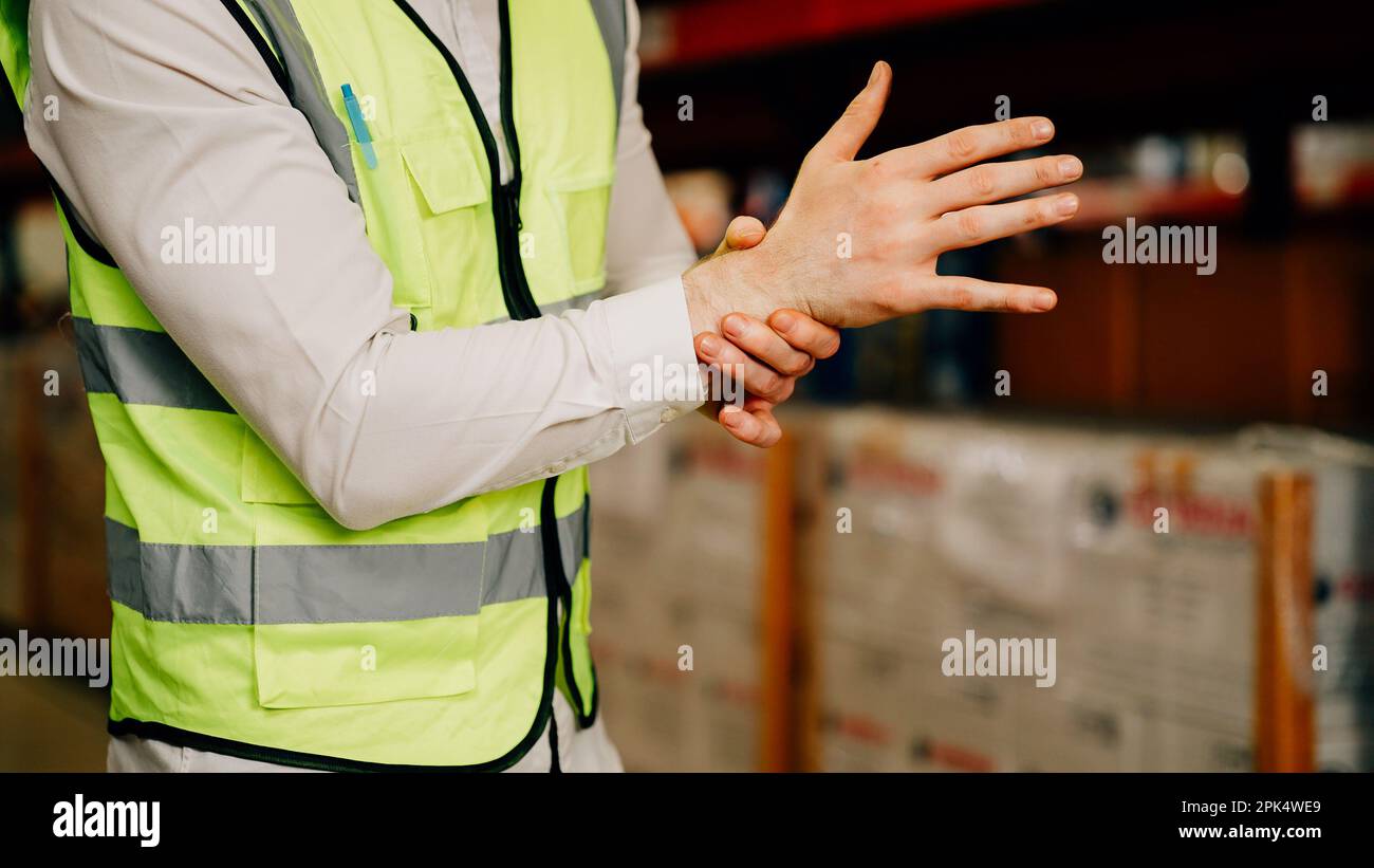 Hardworking male warehouse engineer suffering from hand injury Stock ...