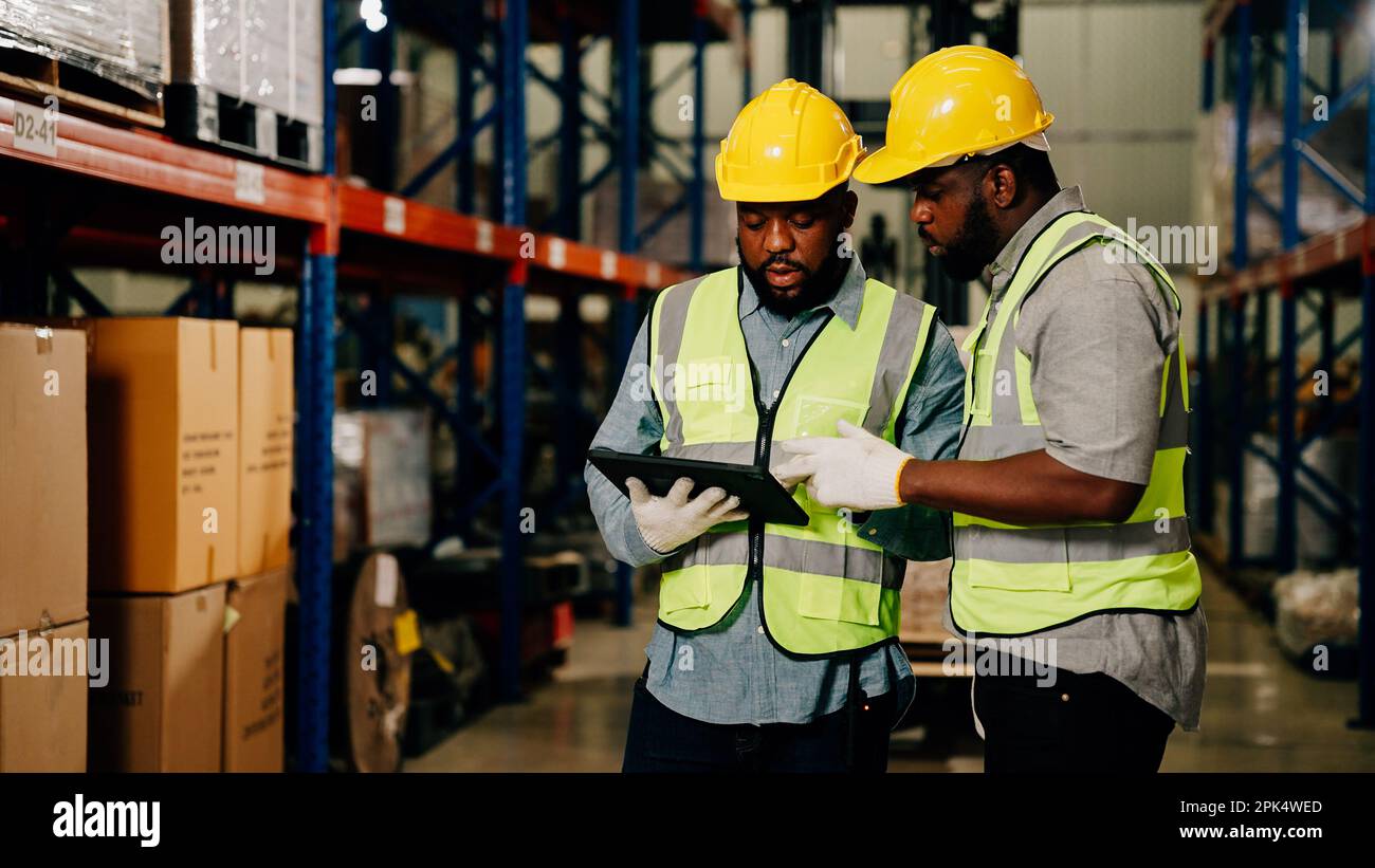 Two warehouse workers checking and controlling boxes in warehouse Stock ...