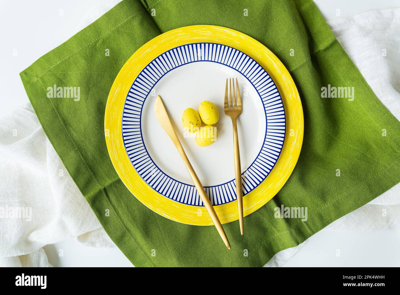 Festive table setting with bright napkins and yellow and blue plates ...