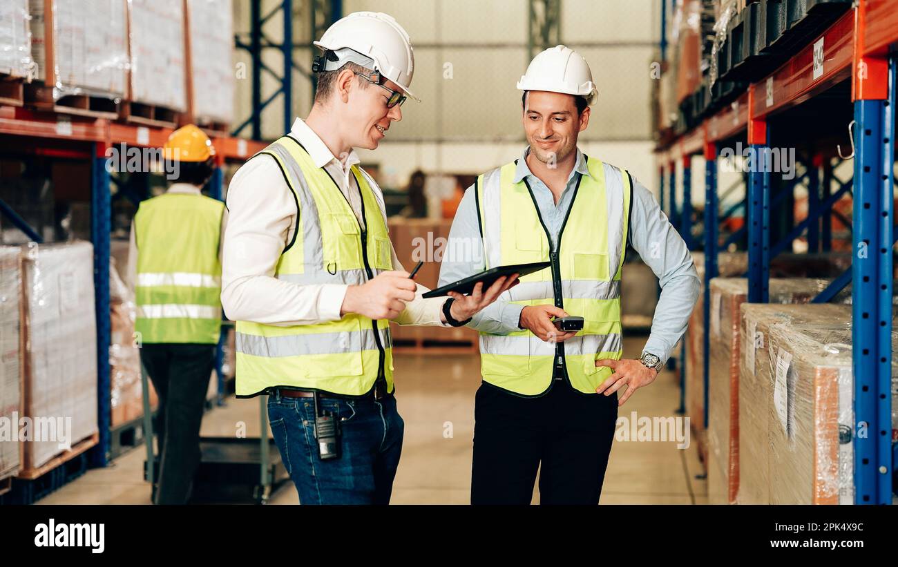 Two warehouse workers with safety helmet working at factory Stock Photo ...