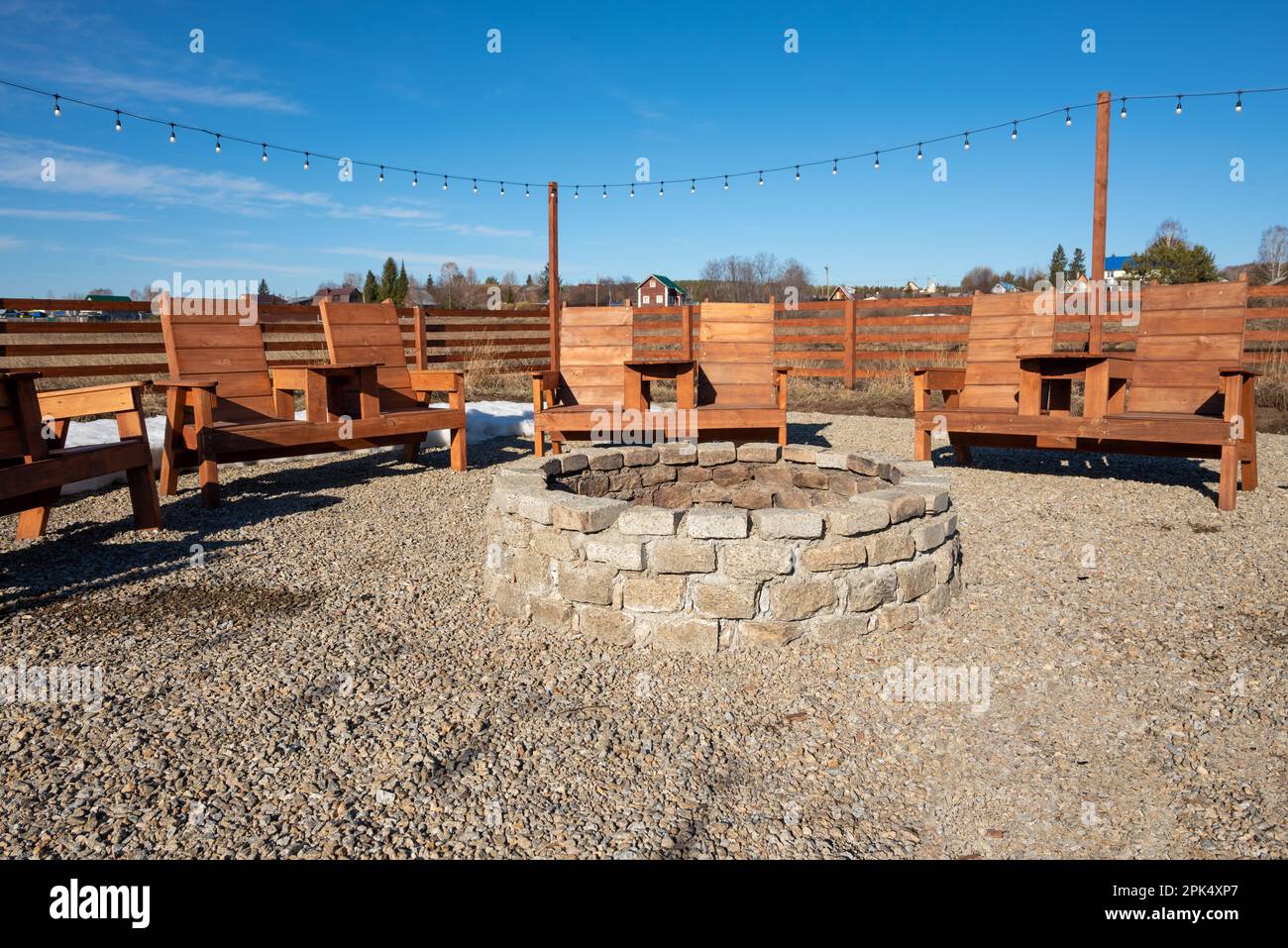 A fire pit with a string of lights hanging from the top Stock Photo - Alamy