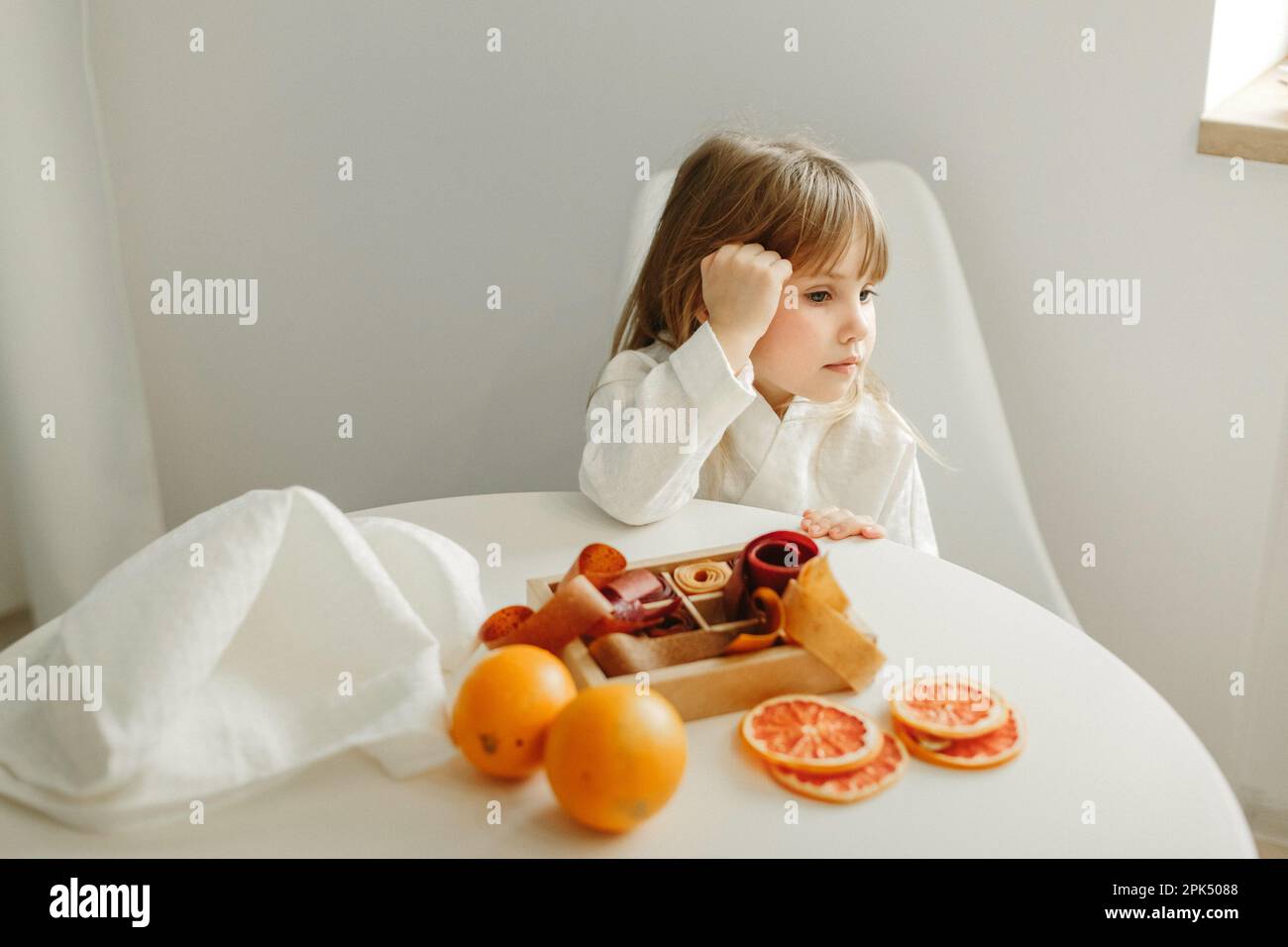 Portrait of a young girl in a dressing gown, who is sitting in the ...