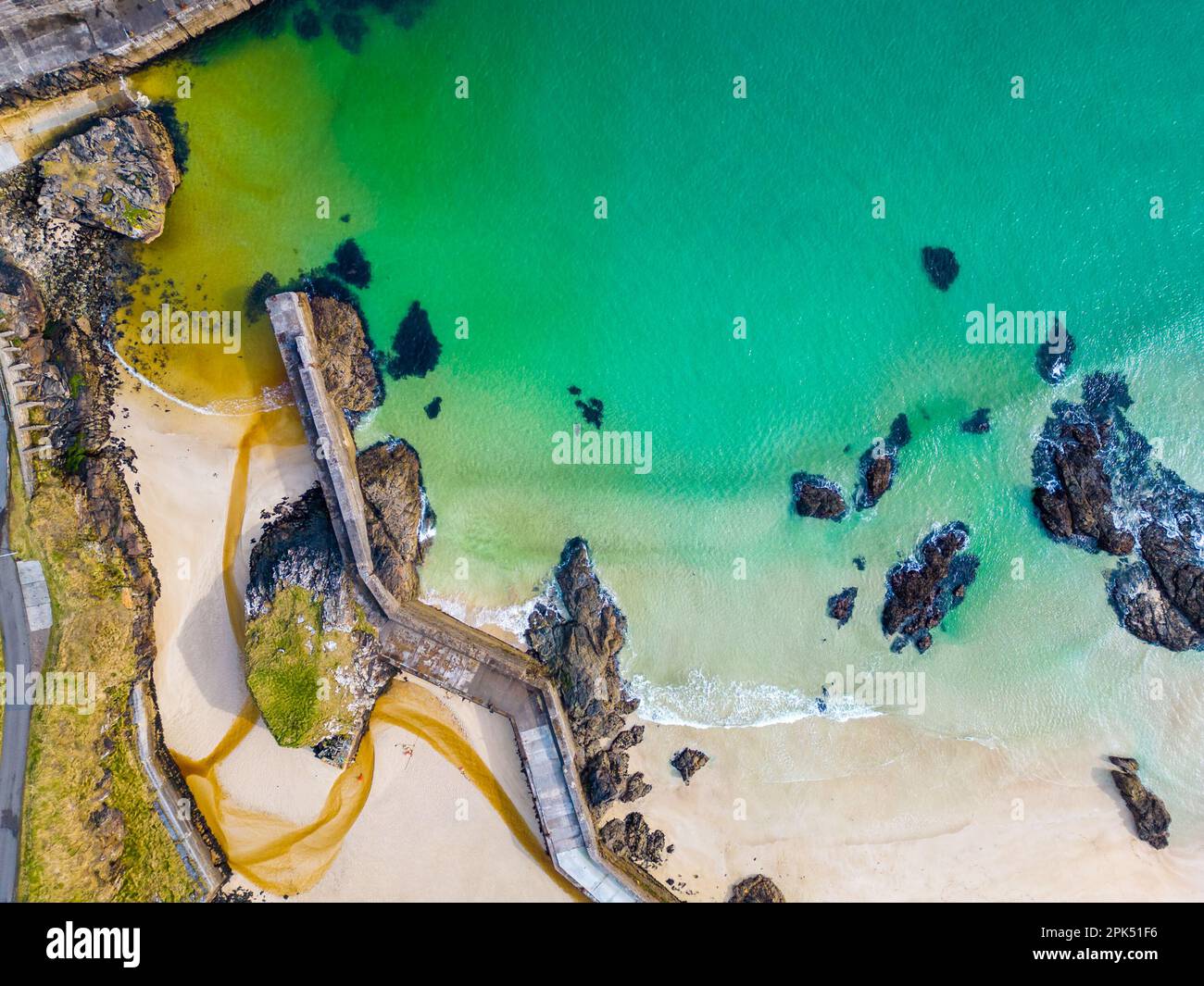 Aerial view of Port of Ness harbour with turquoise water in the Isle of ...